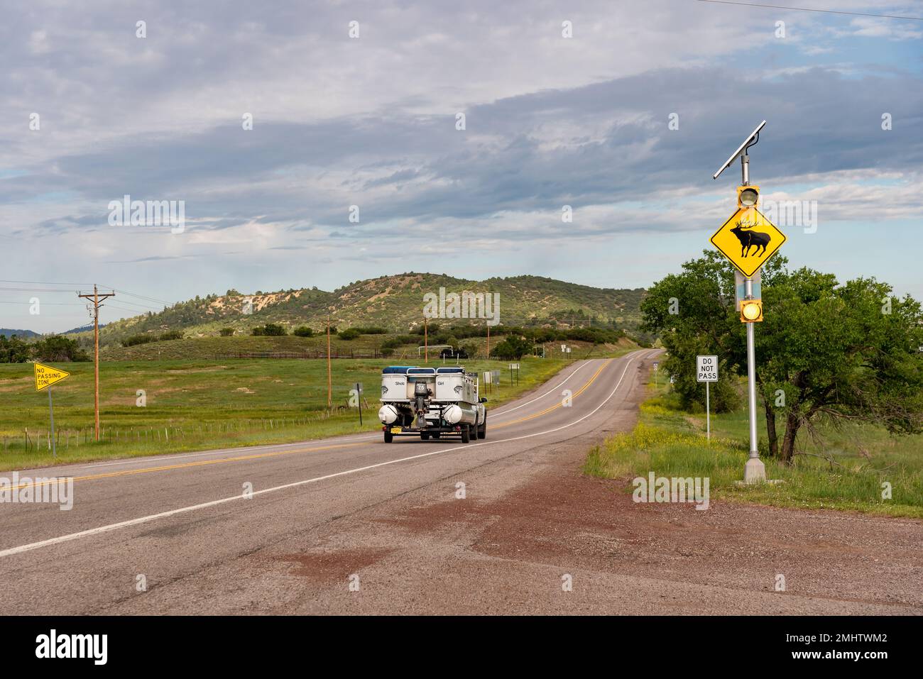 A pickup truck tows a fishing boat with pontoons down Highway 84 in ...