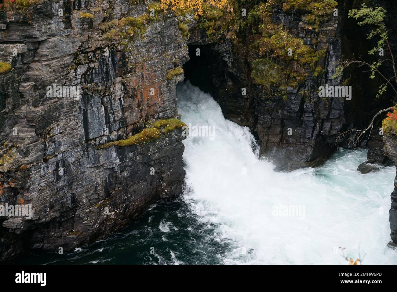 River in Abisko, Sweden in a canyon with steep rock walls and with ...