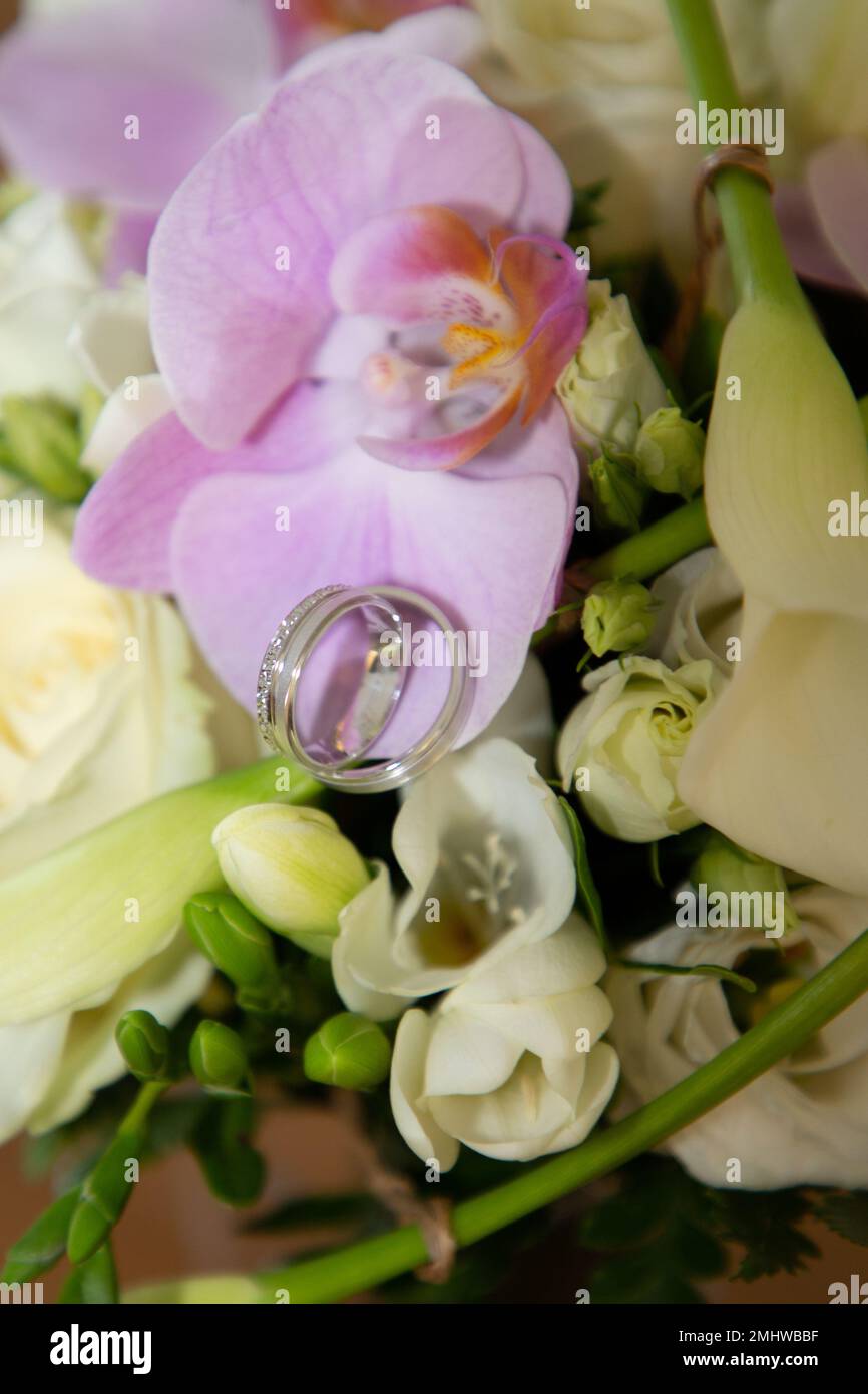 Wedding rings with rose flowers for bride and groom Stock Photo - Alamy