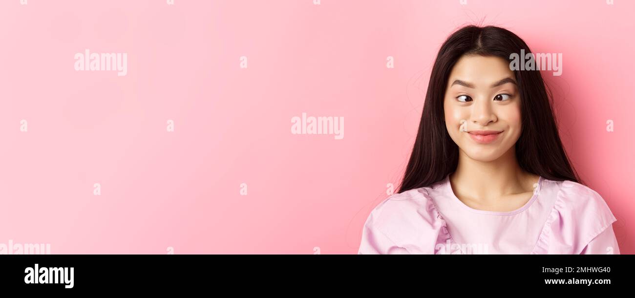 Close-up portrait of funny asian woman squinting eyes and making silly ...