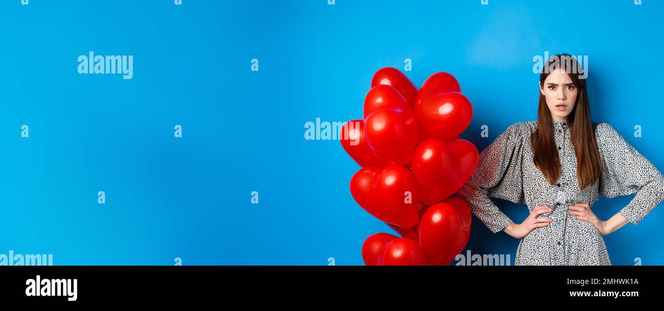 Valentines day. Angry and confused girlfriend in dress, standing near ...