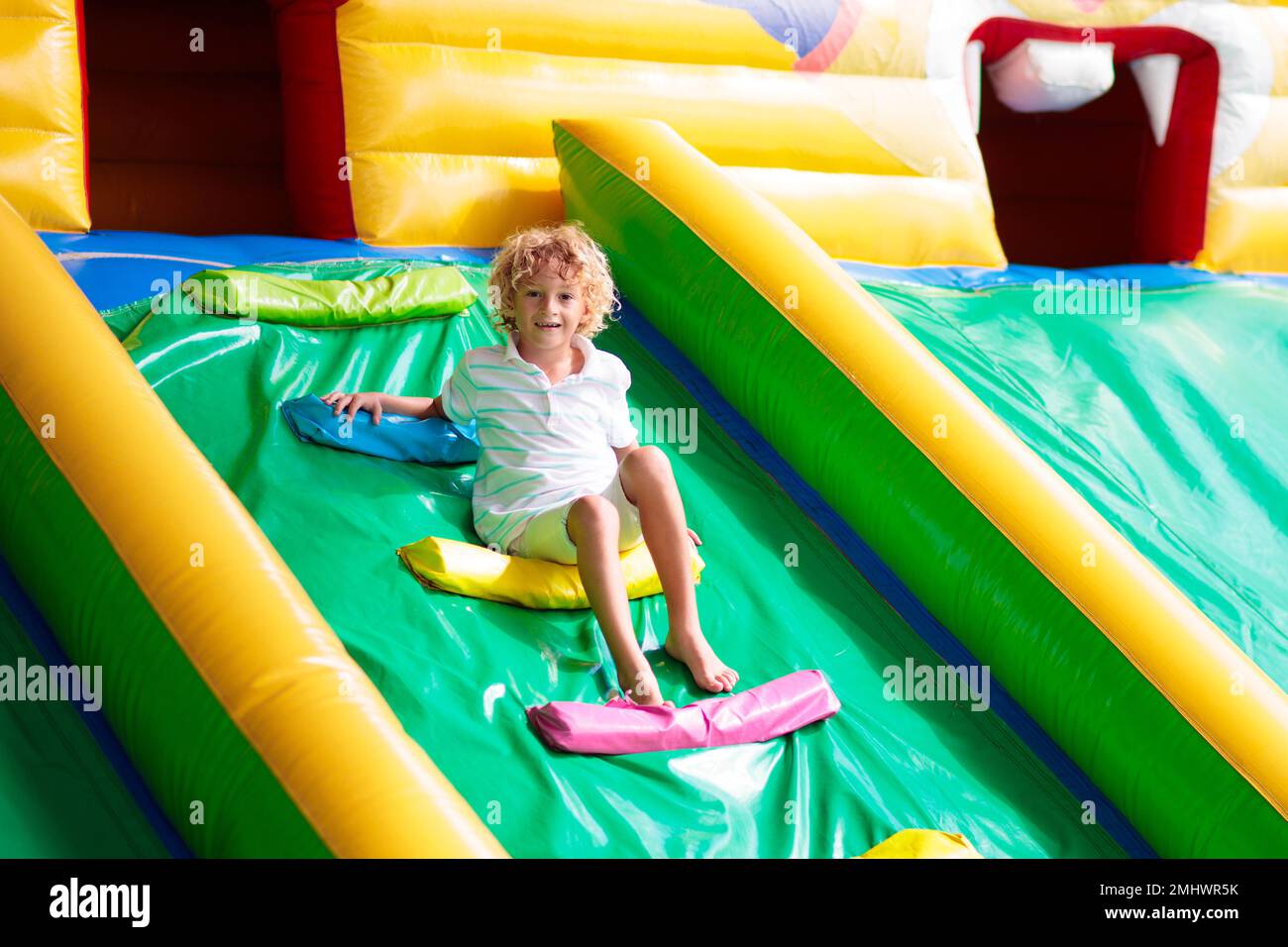 Child jumping on colorful playground trampoline. Kids jump in ...