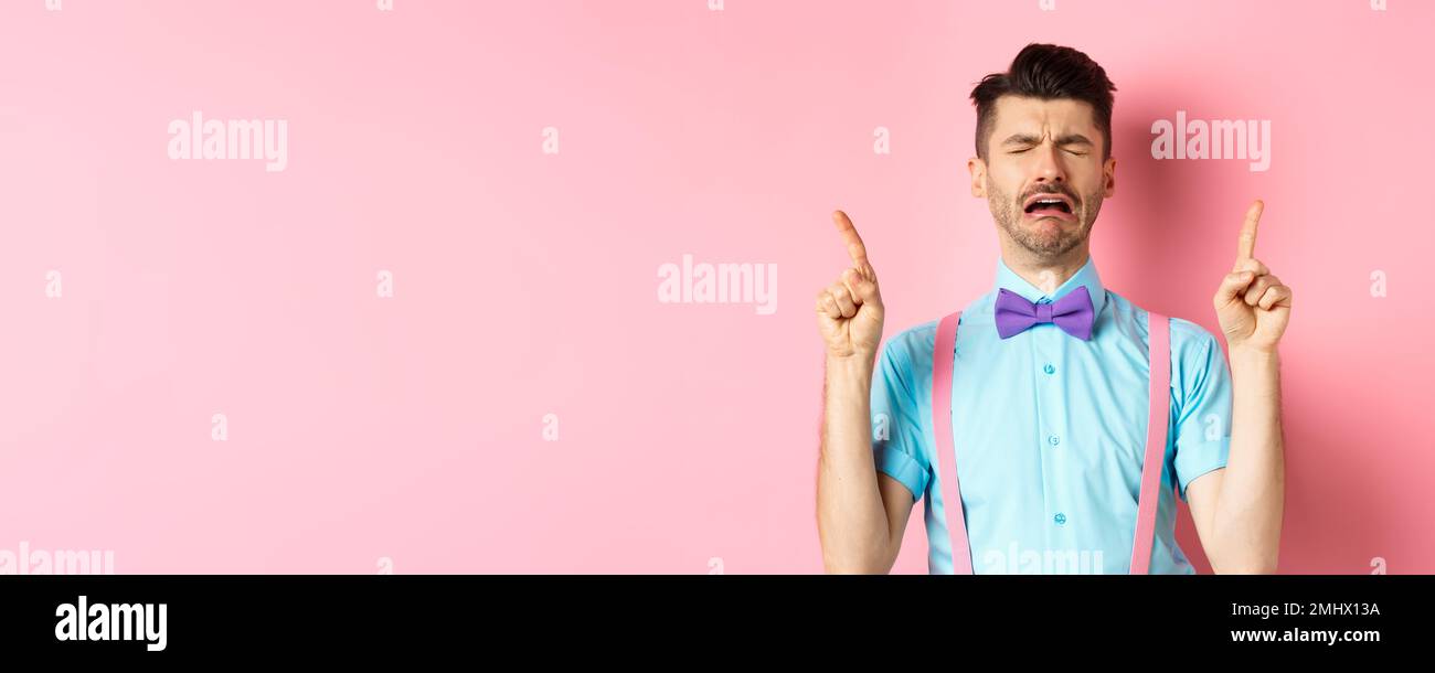 Sad and miserable guy sobbing and crying, pointing fingers up and ...