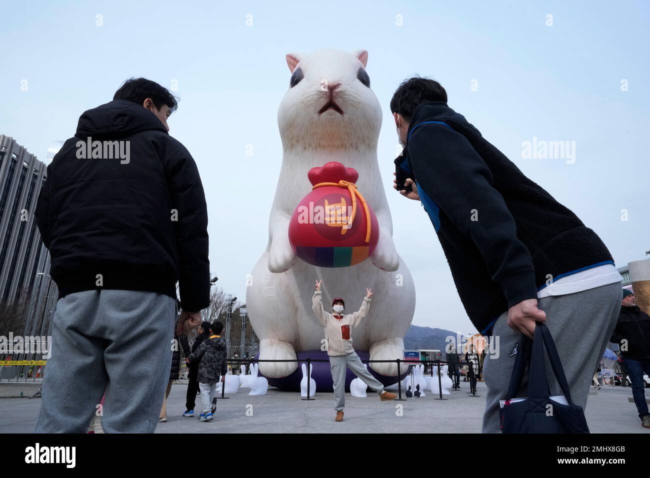 A woman poses under a giant rabbit installation to celebrate the Year ...
