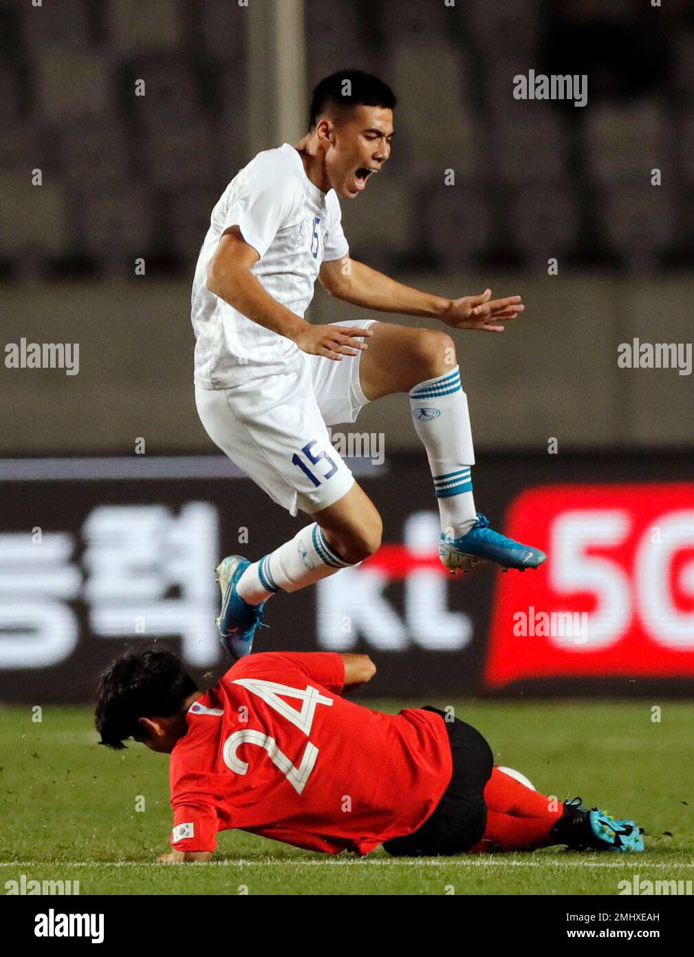 Uzbekistan's Oybek Rustamov, top, jumps a tackle by South Korea's Maeng ...