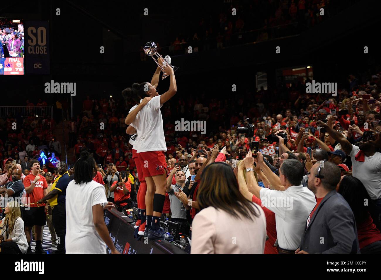 Washington Mystics guard Natasha Cloud raises the trophy to the crowd ...