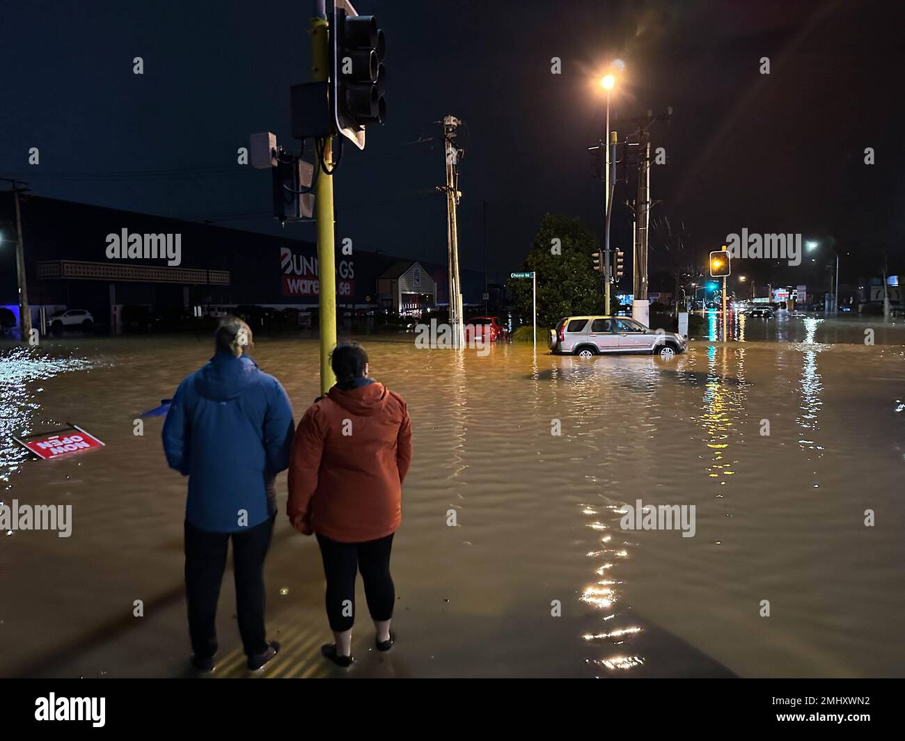 Aukland, New Zealand. 27th Jan, 2023. People look at a flooded street in Auckland, New Zealand ...