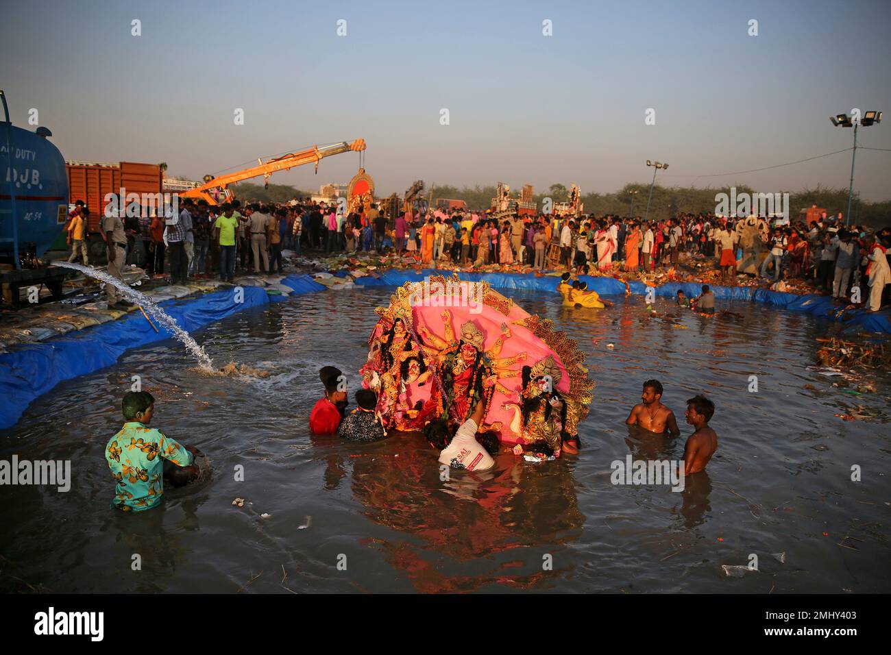 Indian Hindu devotees prepare to immerse an idol of goddess Durga in a ...