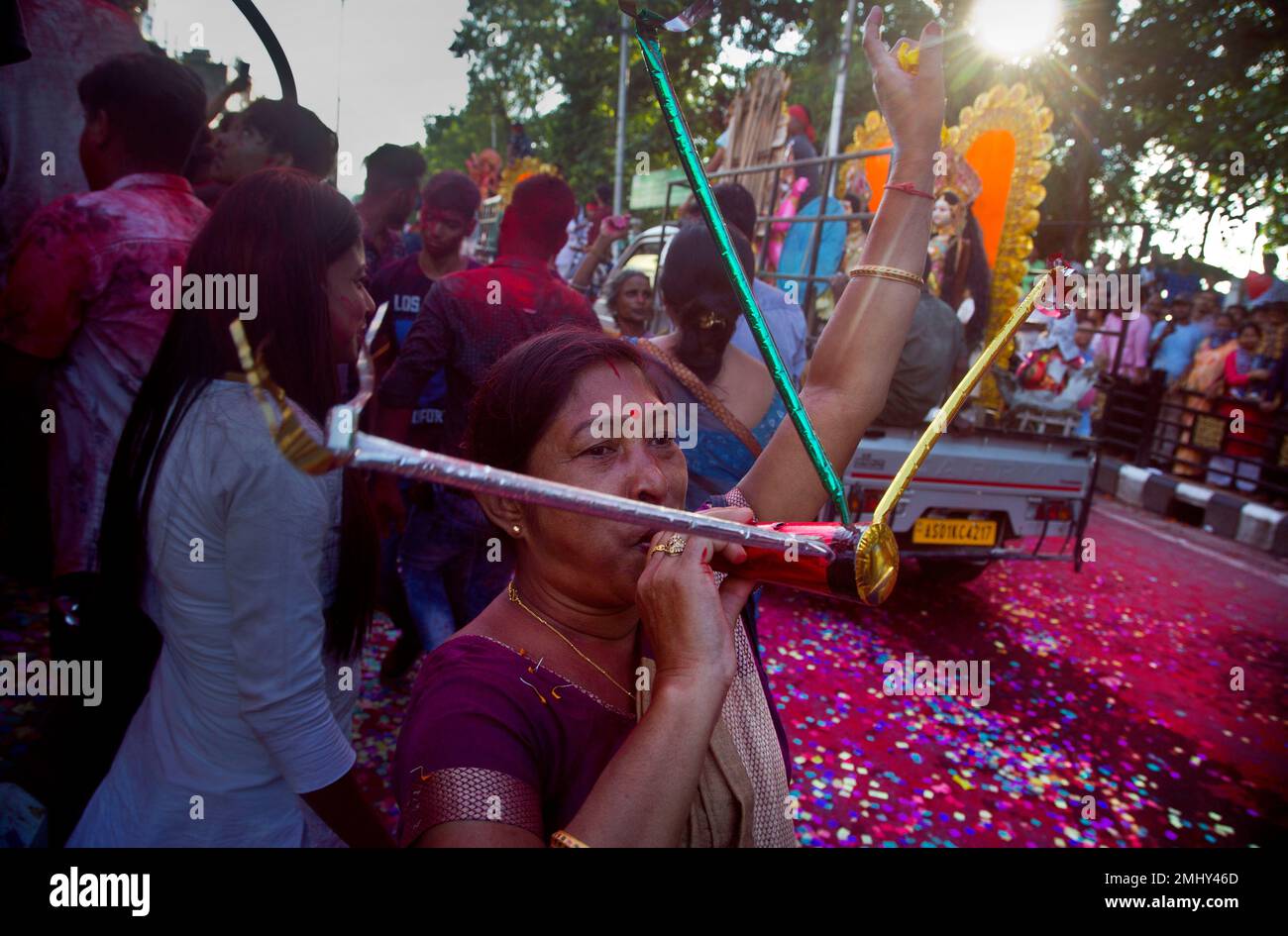 An Indian devotee blows a musical instrument during a procession for ...