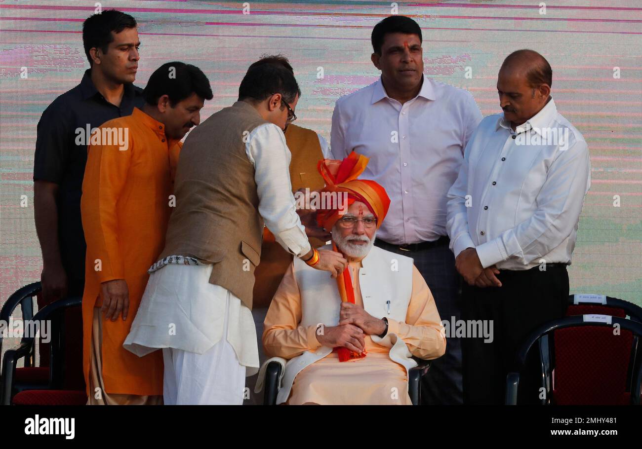 Indian Prime Minister Narendra Modi is presented with a turban as he ...