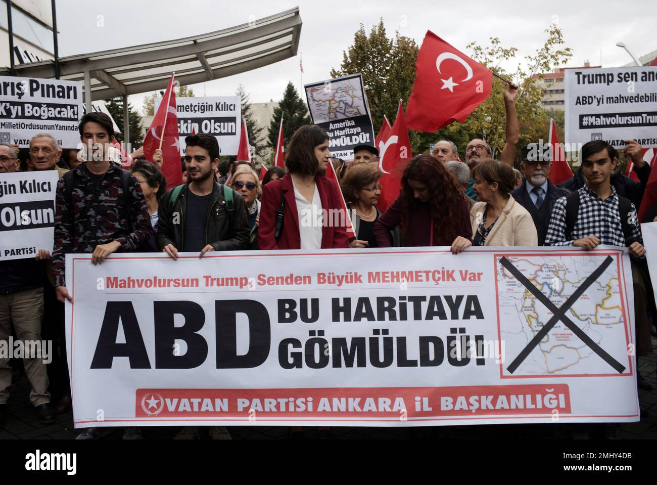 Members of a Turkish political party hold national flags and a banner ...