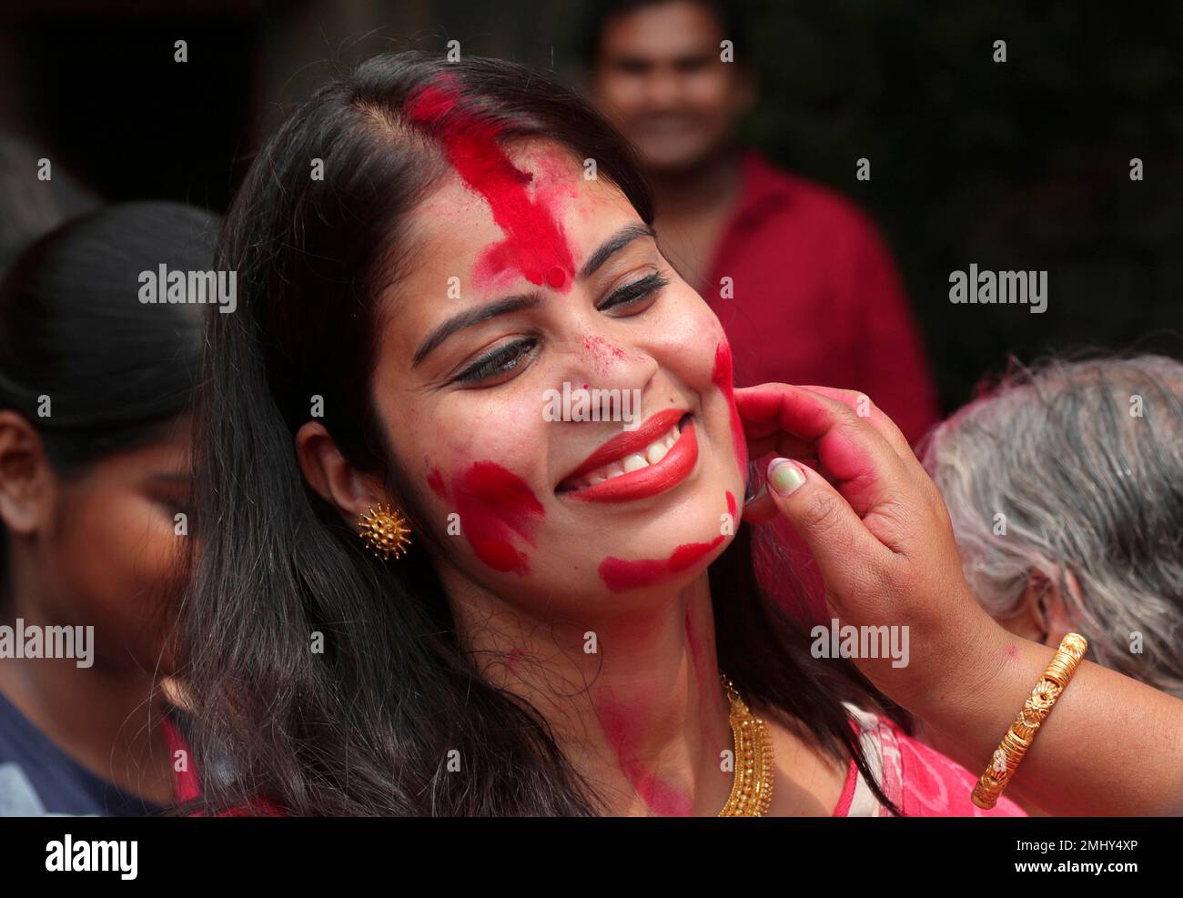 An Indian Hindu woman applies vermillion powder on another on the last ...