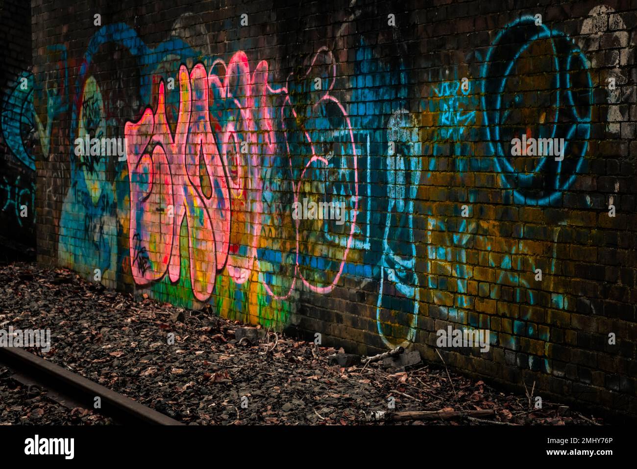 Colorful graffiti artwork hidden on an old rail track Stock Photo - Alamy