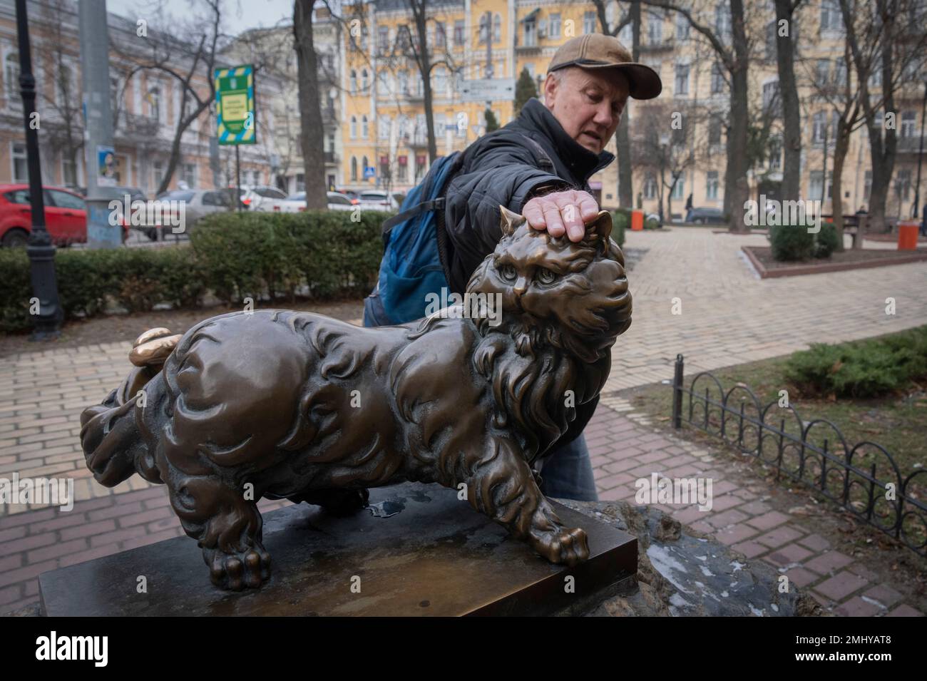 A man touches a cat sculpture for good luck in a city park in central ...