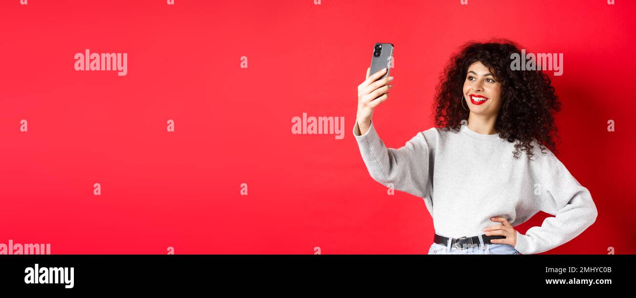 Image of stylish female blogger taking selfie on smartphone, posing for ...