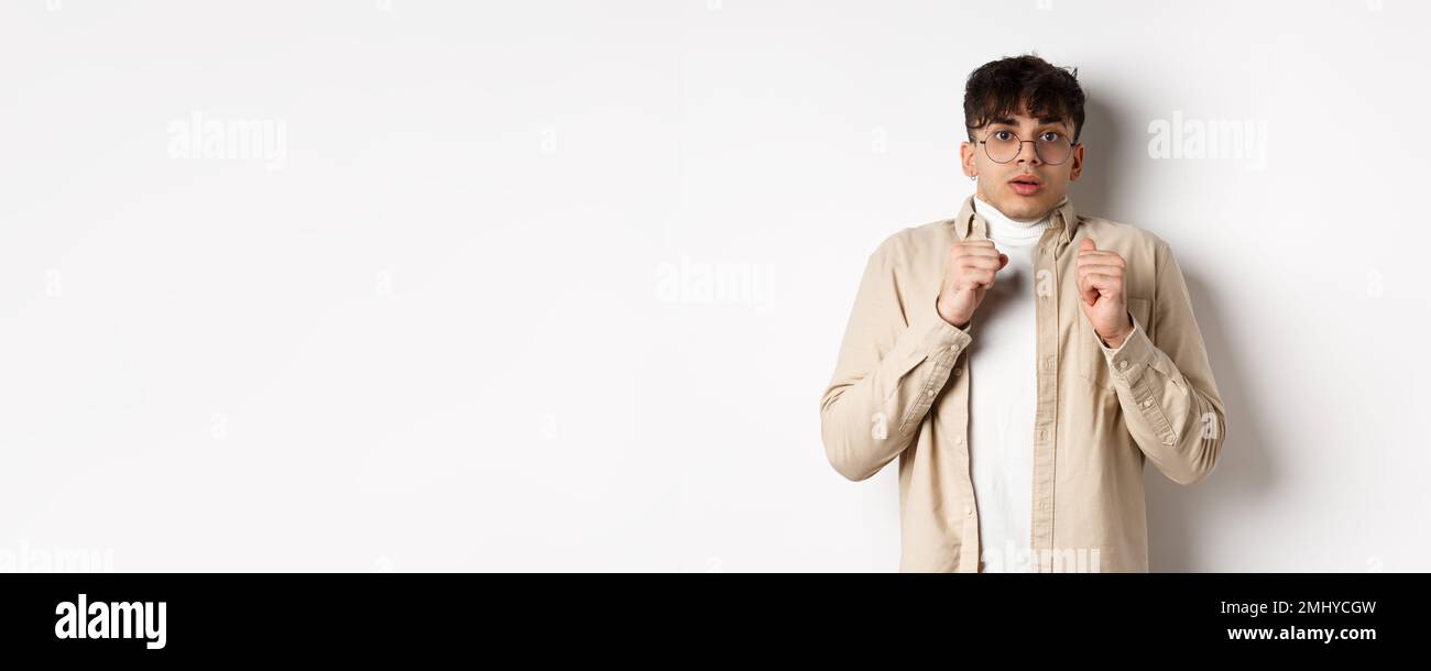 Startled man freeze from fear, gasping and looking scared at camera ...