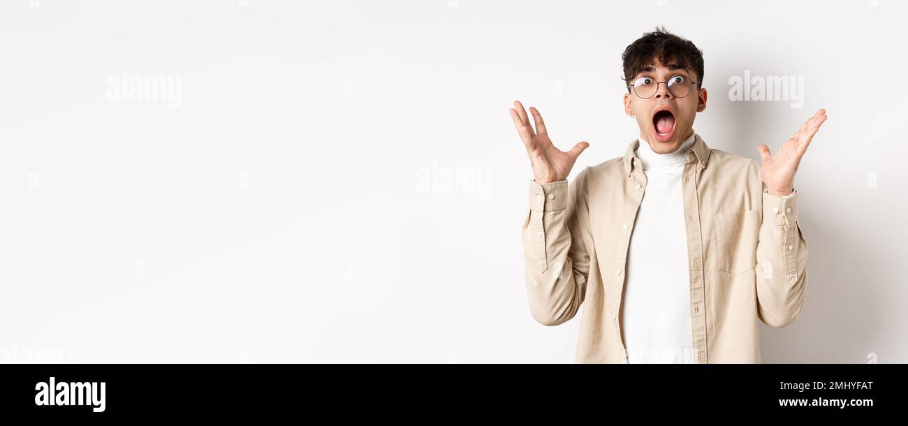 Scared young man in panic, screaming and looking axious, jumping ...