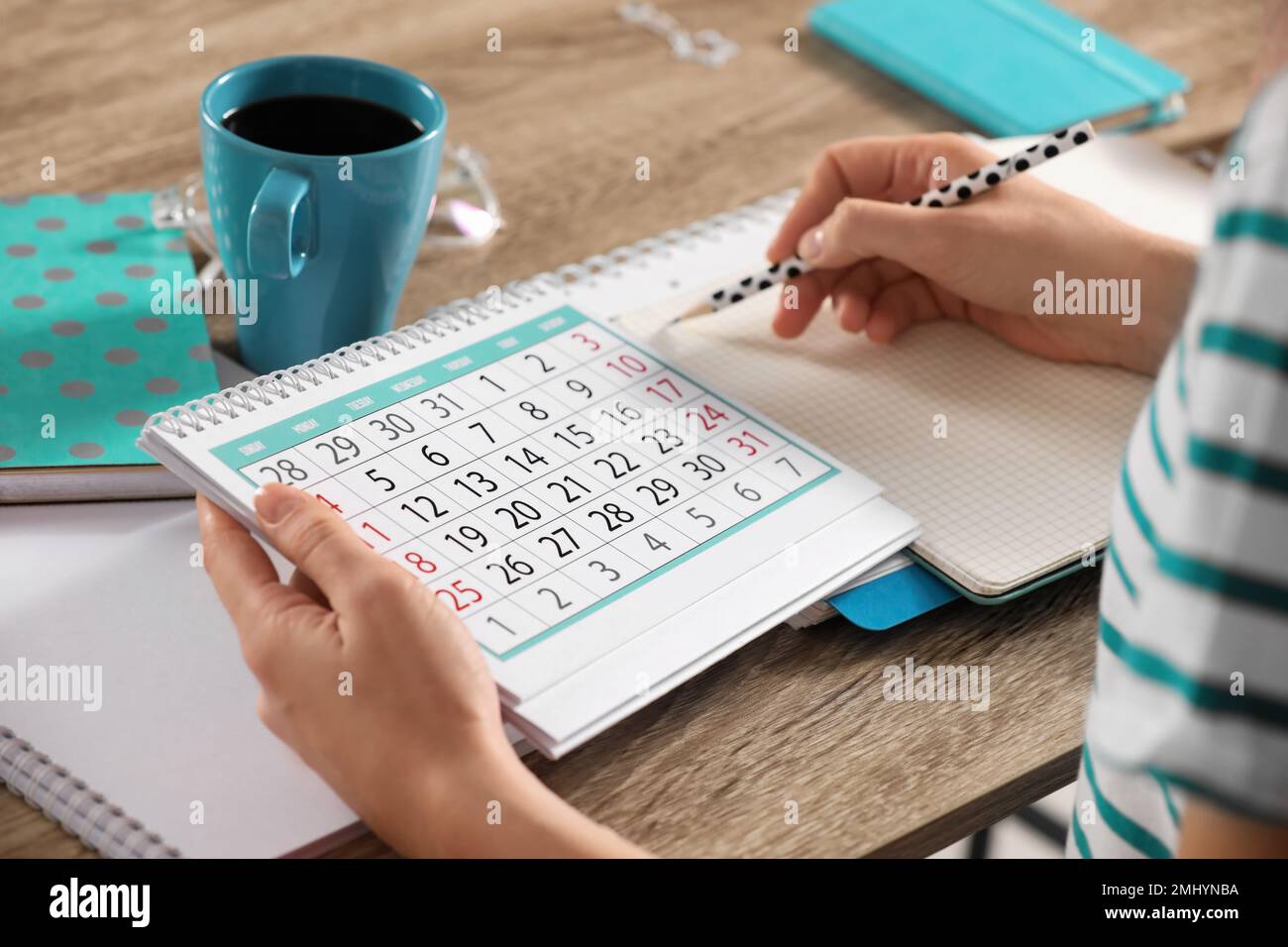 Woman making schedule using calendar at wooden table, closeup Stock ...