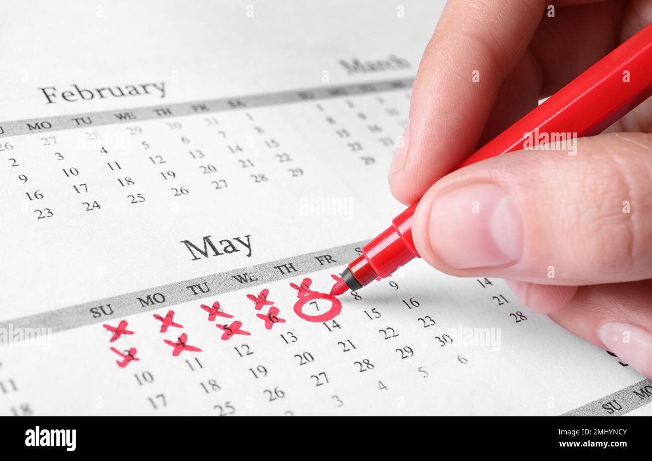 Woman marking date in calendar with red felt pen, closeup Stock Photo ...