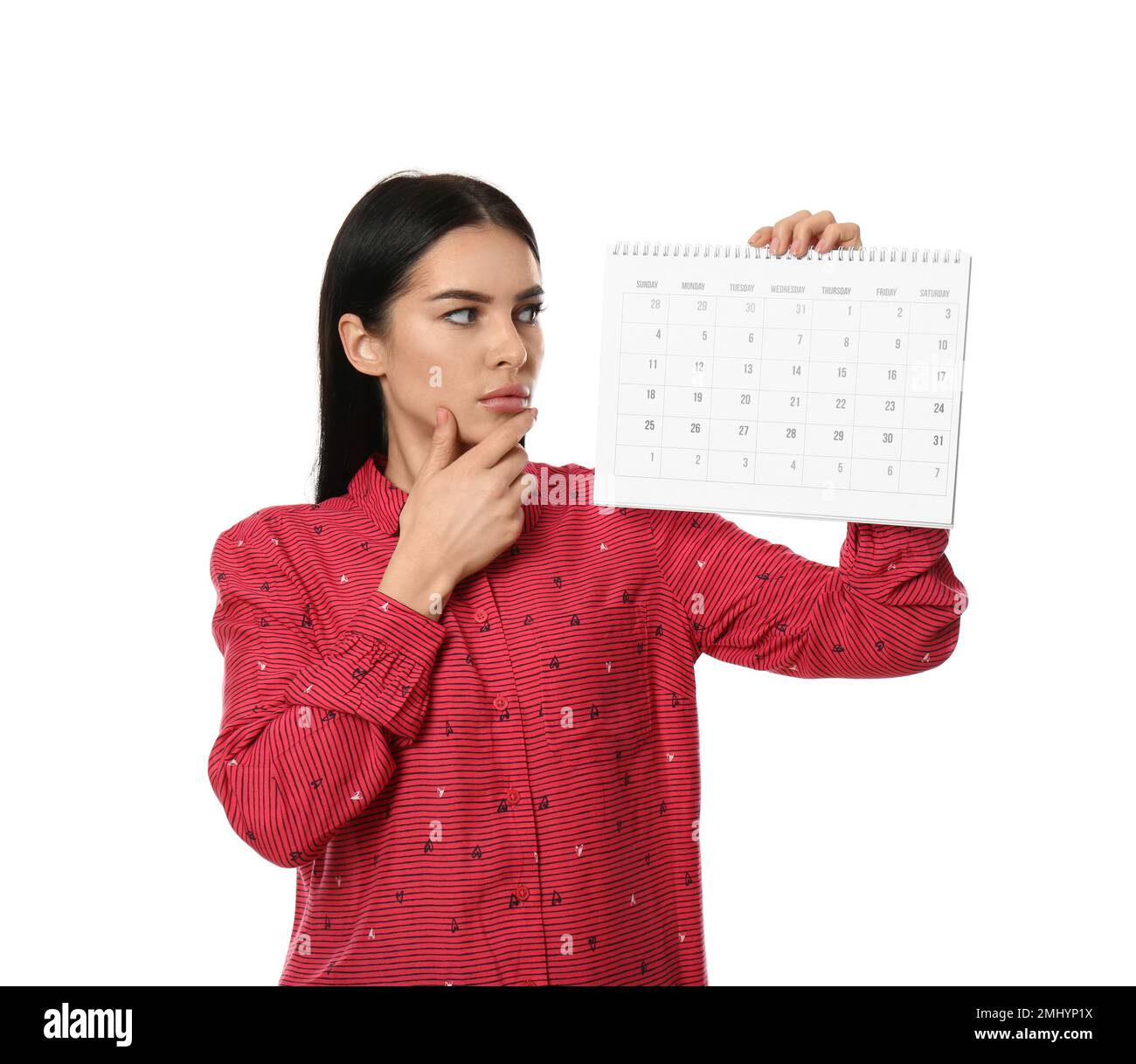 Pensive young woman holding calendar with marked menstrual cycle days ...