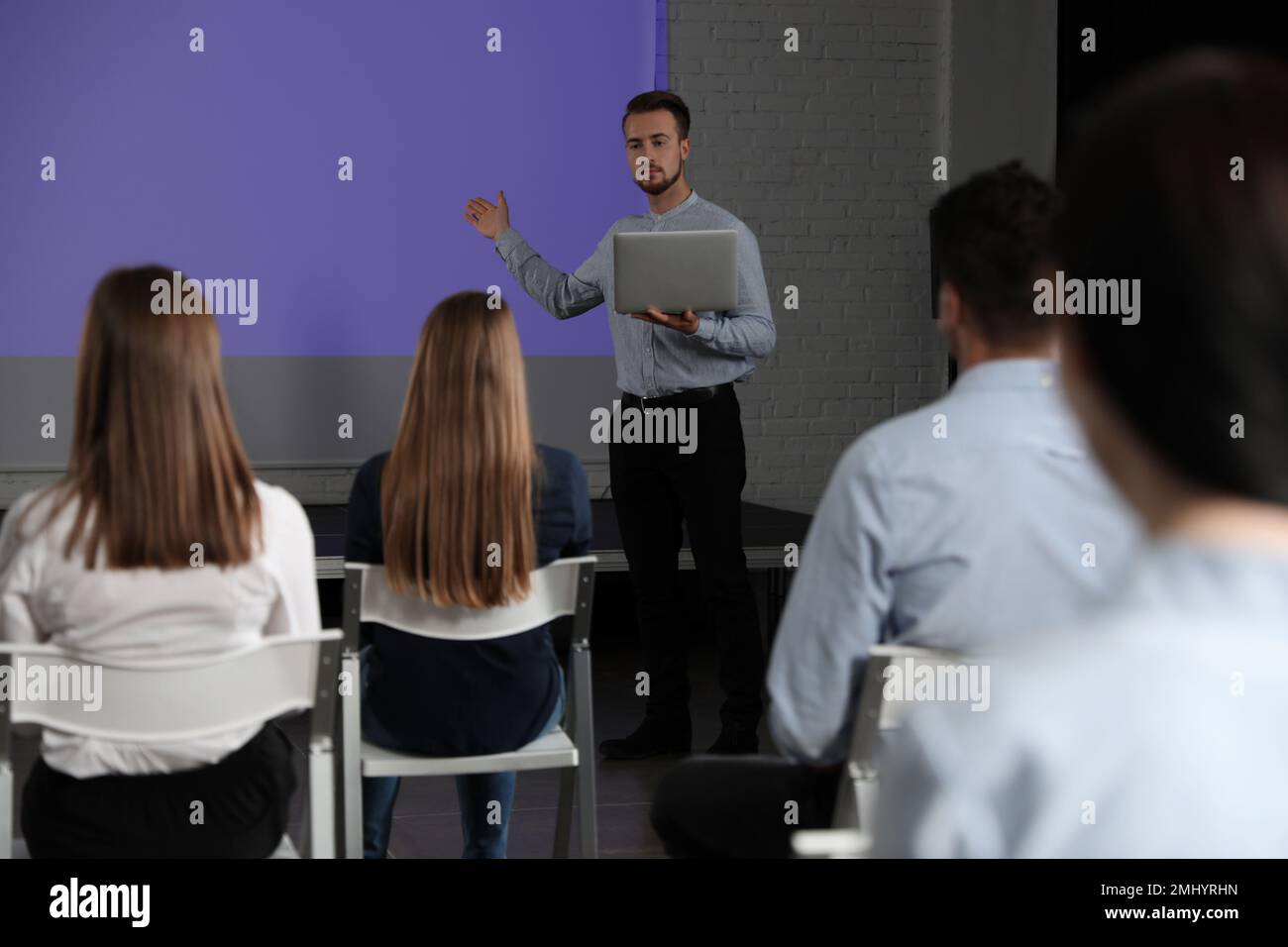 Male business trainer with laptop giving lecture in conference room ...