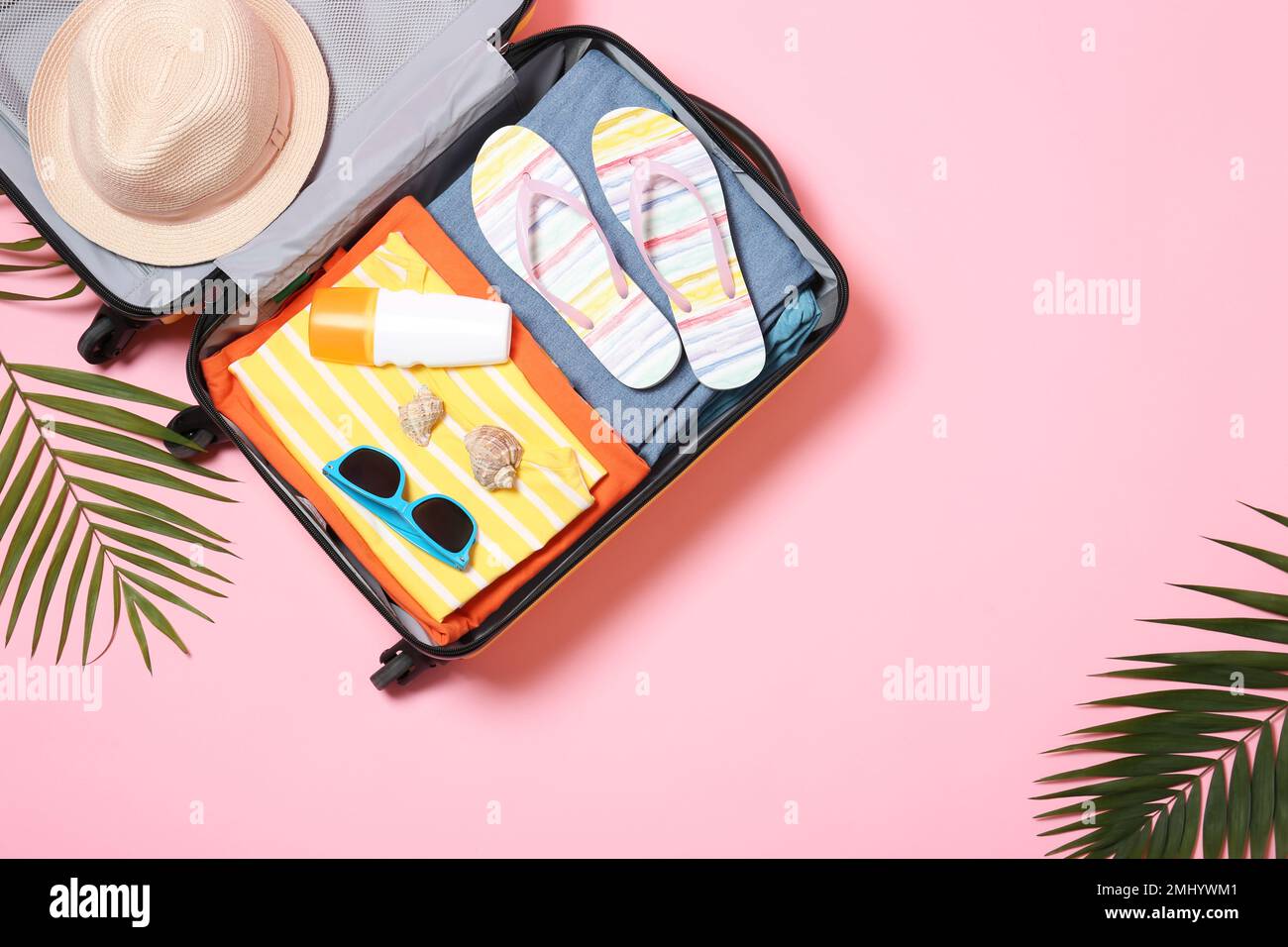 Flat lay composition with open suitcase and space for text on pink ...