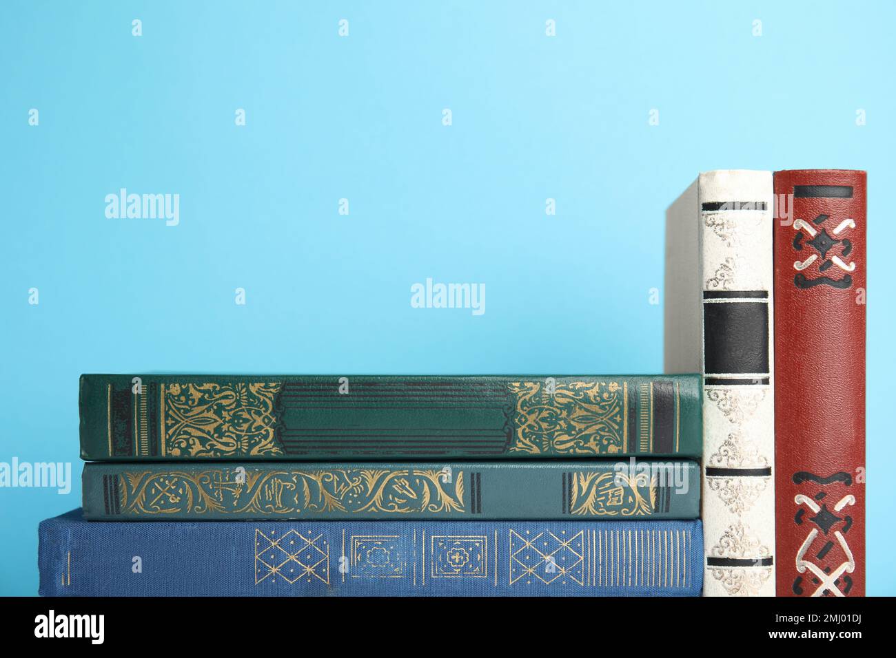 Collection of old books on light blue background Stock Photo - Alamy