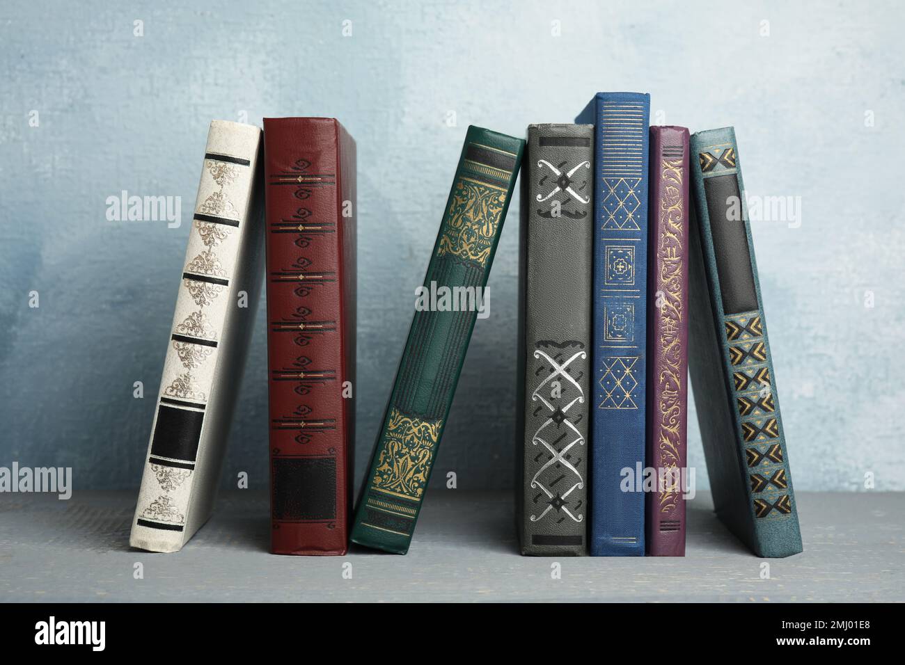 Collection of old books on grey wooden shelf Stock Photo - Alamy