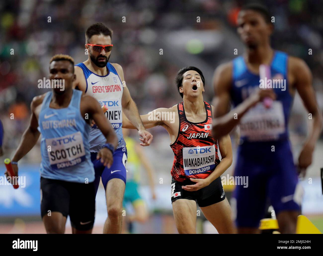 Japan's Kota Wakabayashi, center, reacts as he finishes a men's 4x400 ...