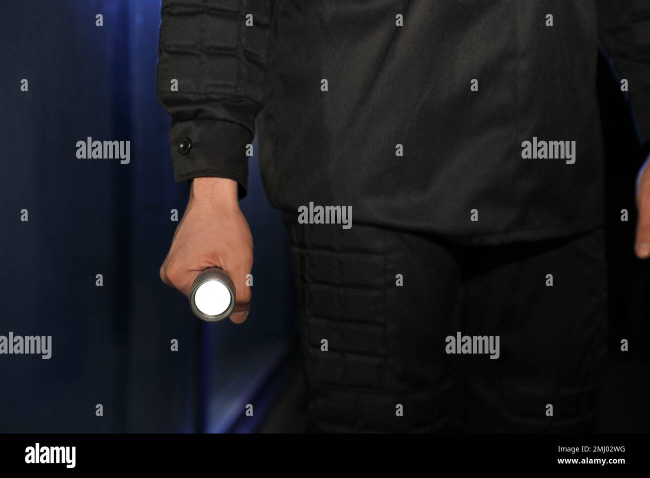Male security guard with flashlight in dark room, closeup Stock Photo ...