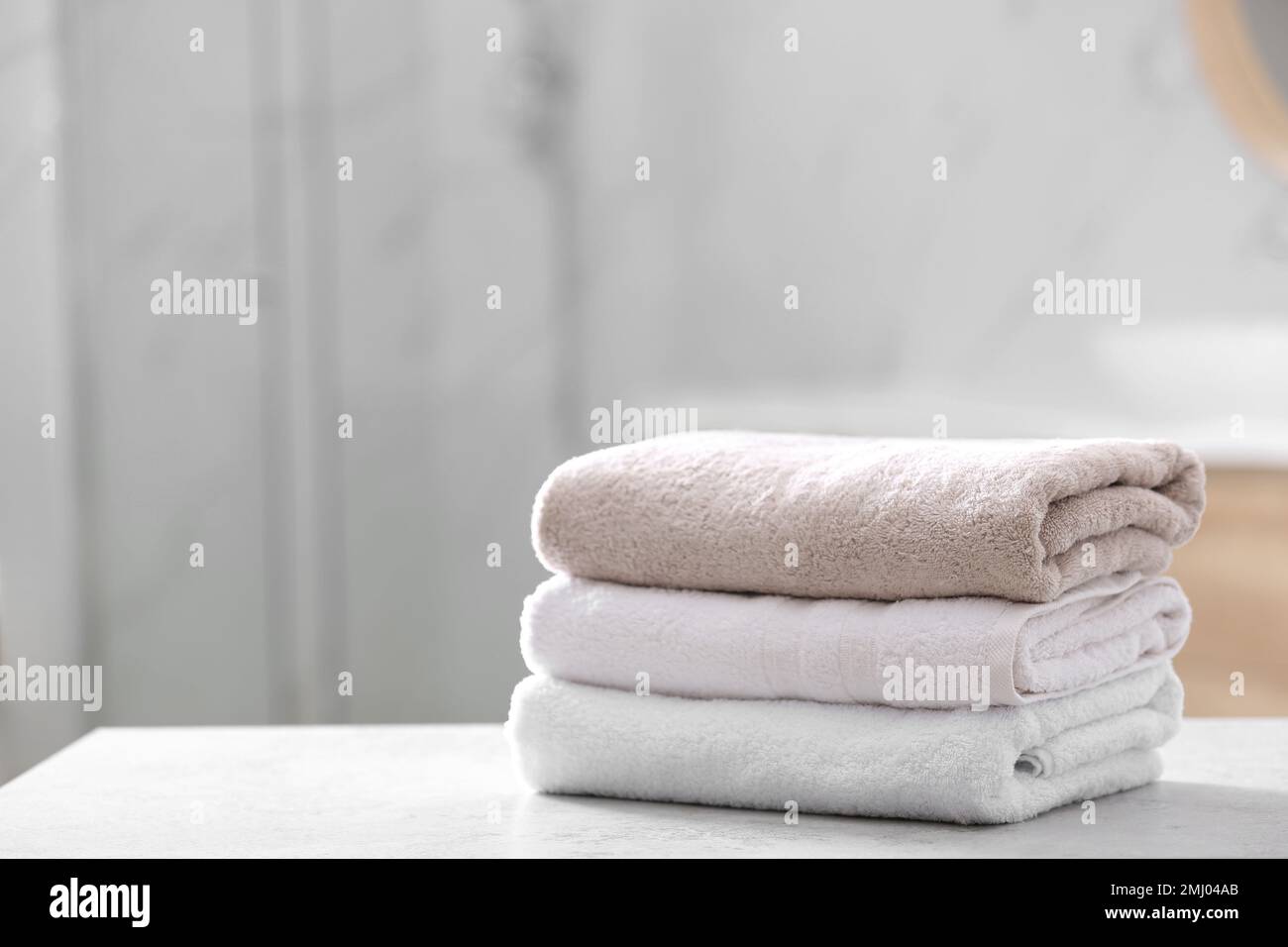 Stack of clean towels on table in bathroom Stock Photo - Alamy