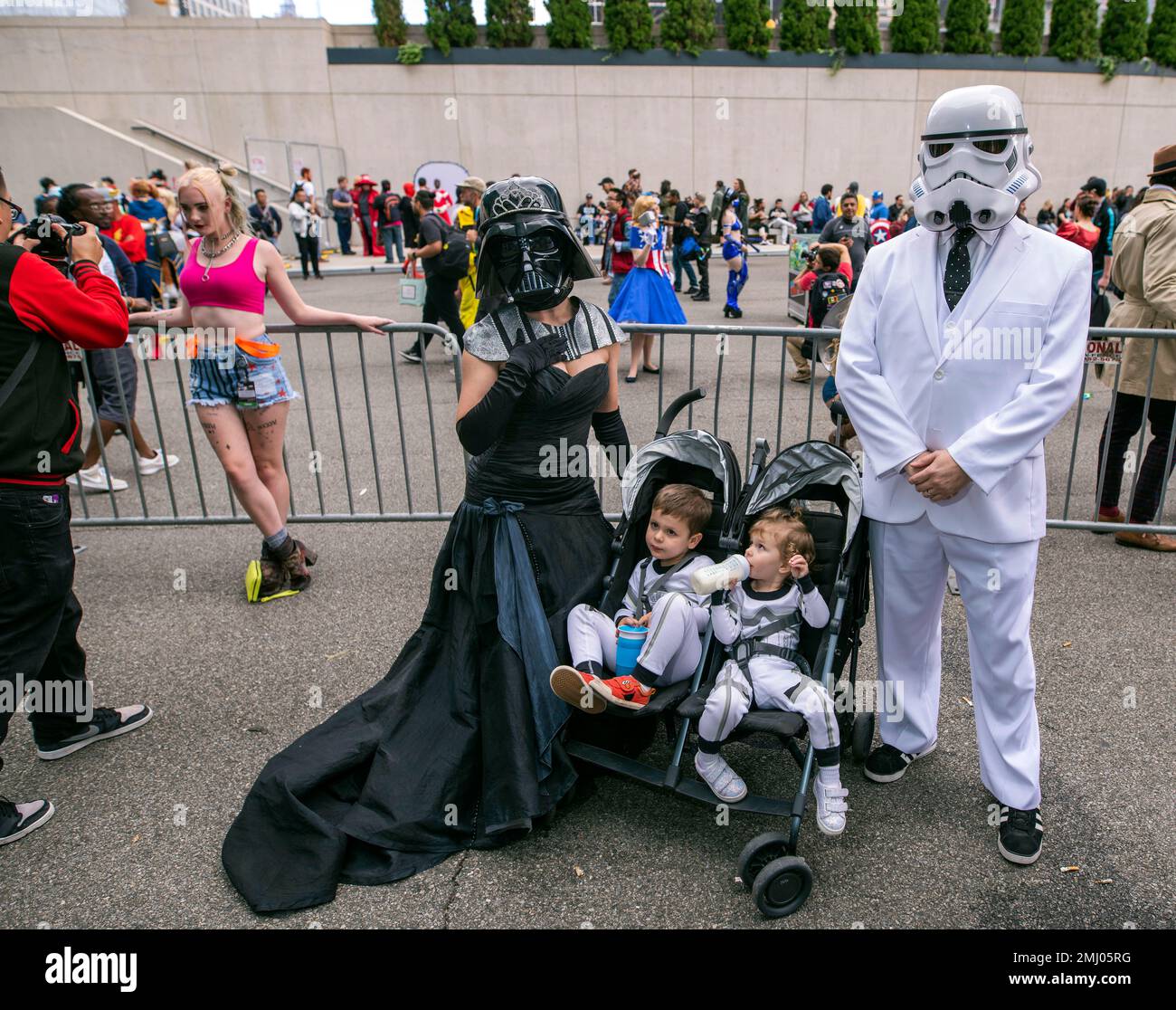 Attendees dressed as a Darth Vader and Stormtrooper family pose during ...