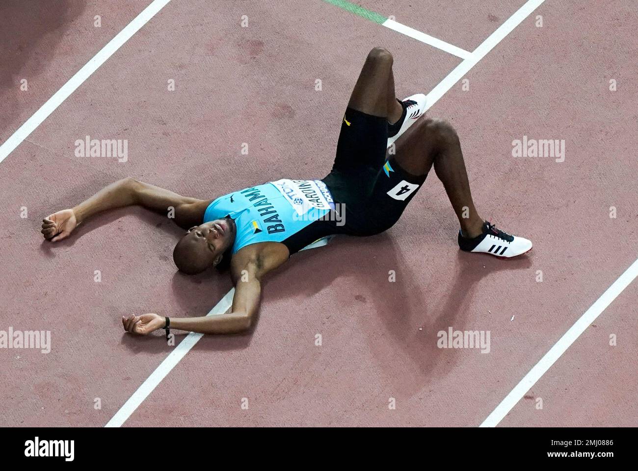Steven Gardiner, of Bahamas, lays on the track after winning the men's ...