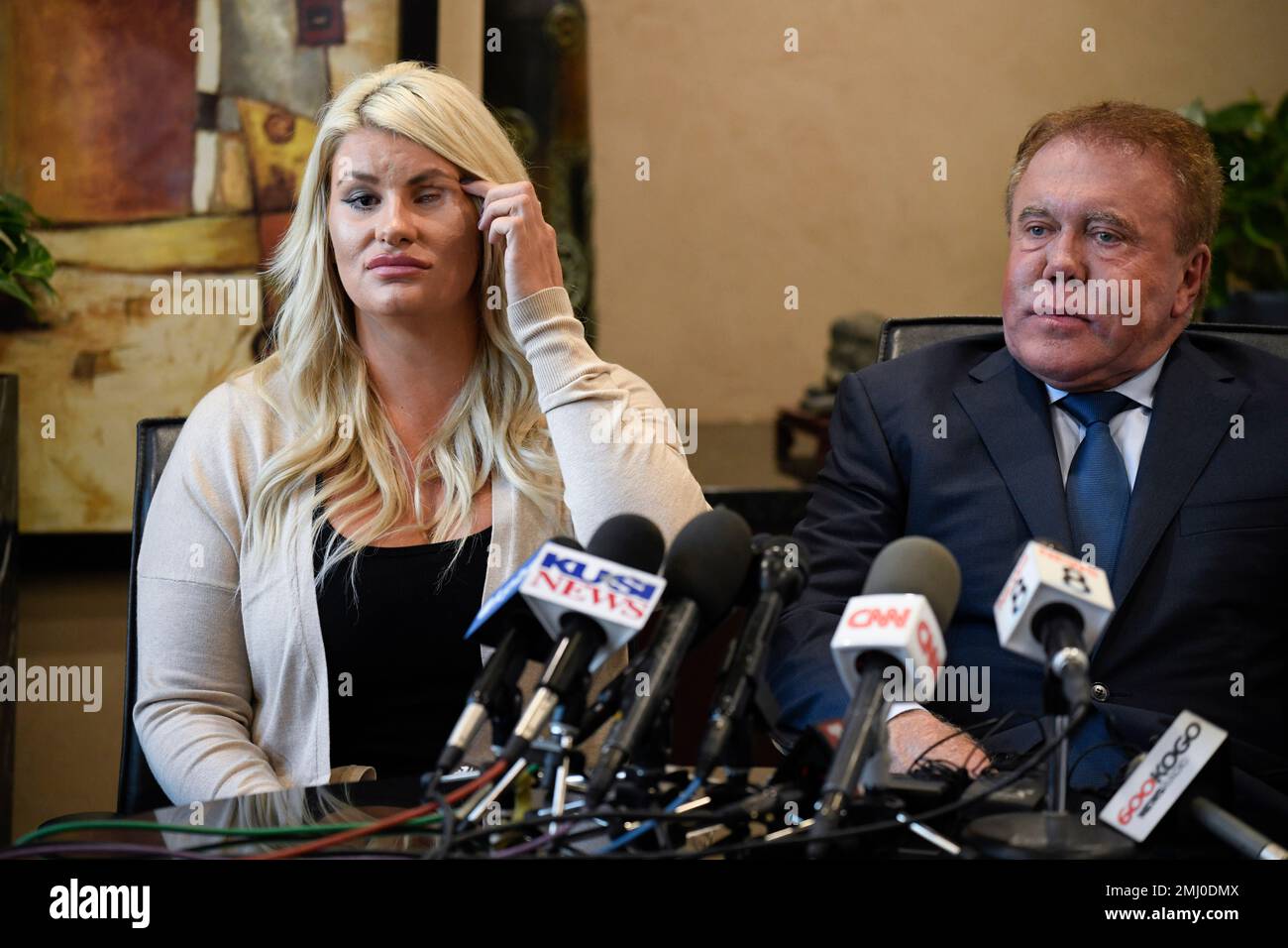 Chelsea Romo, left, pulls the her hair out of the way to show her left ...