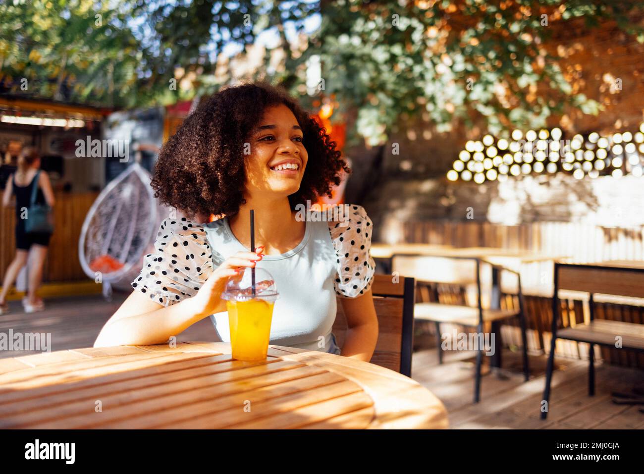 Happy cute african american teenage girl drinking lemonade or cocktail ...