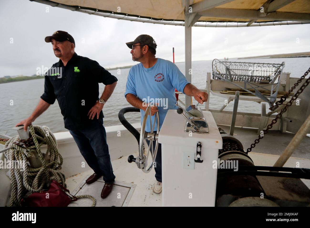 In this March 11, 2019, photo, Robert Campo, right, an oyster fisherman ...