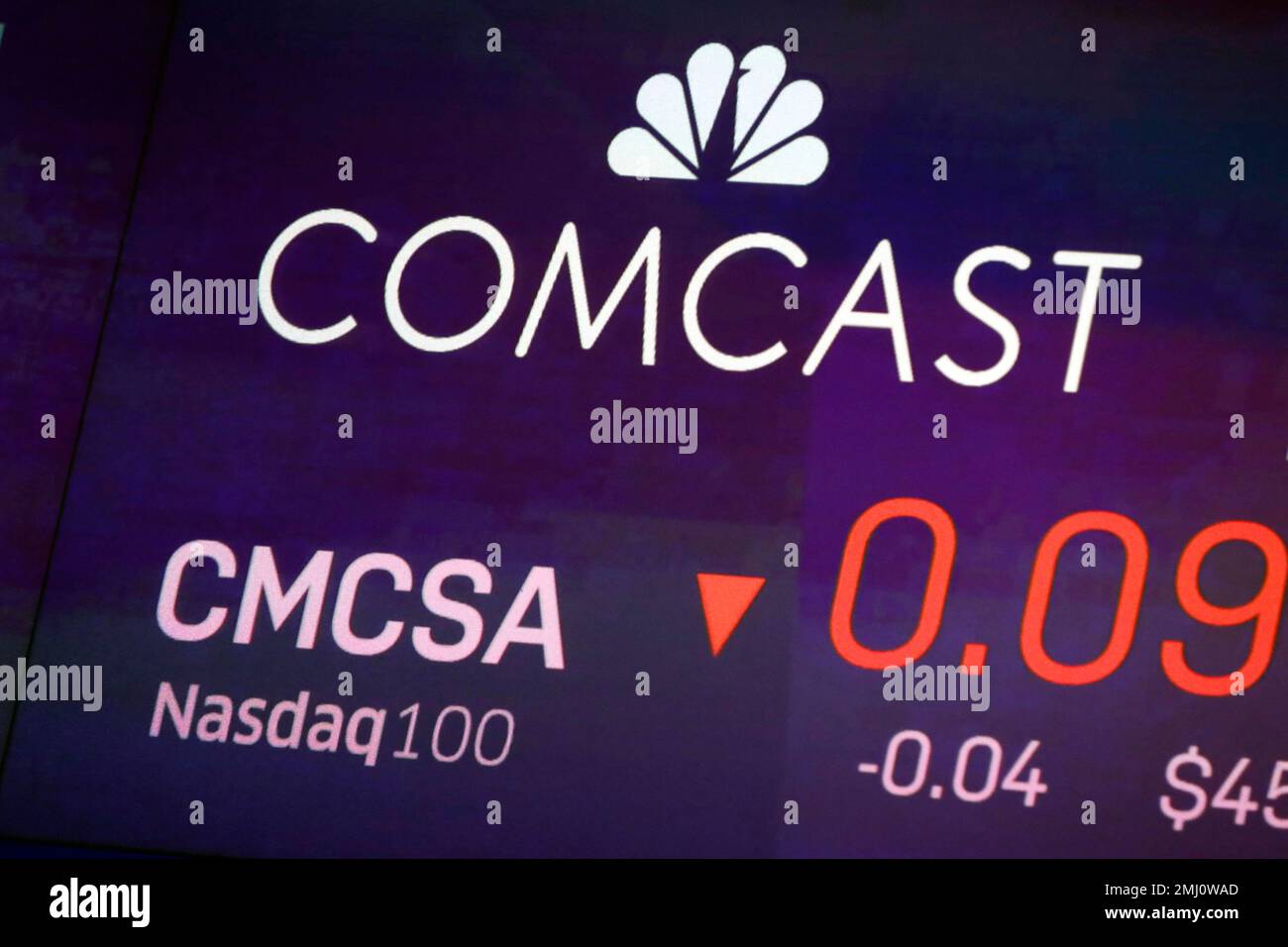 The symbol for Comcast appears on a screen at the Nasdaq MarketSite, in ...