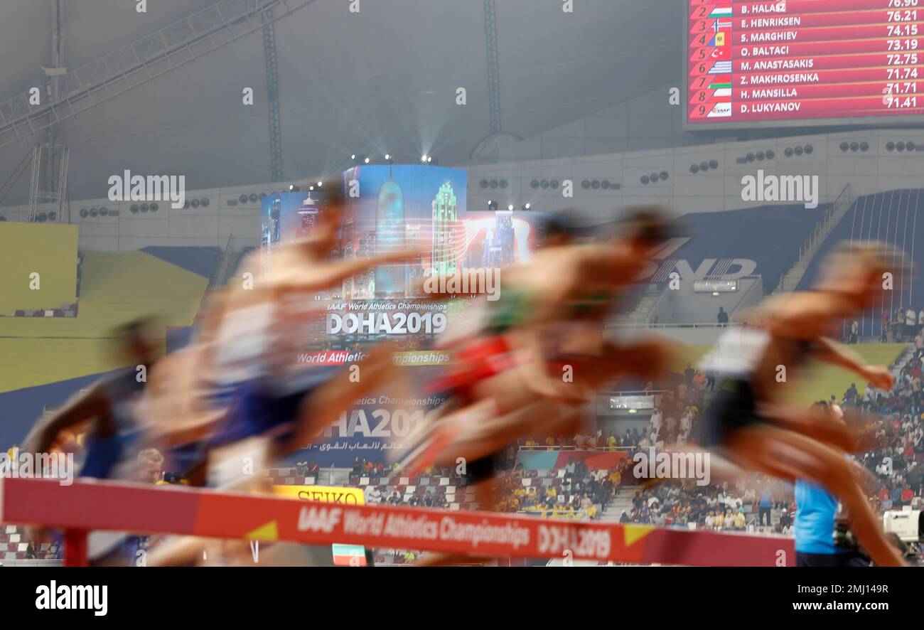 Athletes clear a barrier in the men's 3000 meter steeplechase heats at ...