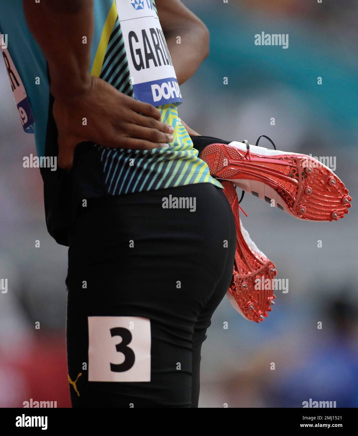 Rusheen Mcdonald, of Jamaica holds his spikes after finishing a men's ...