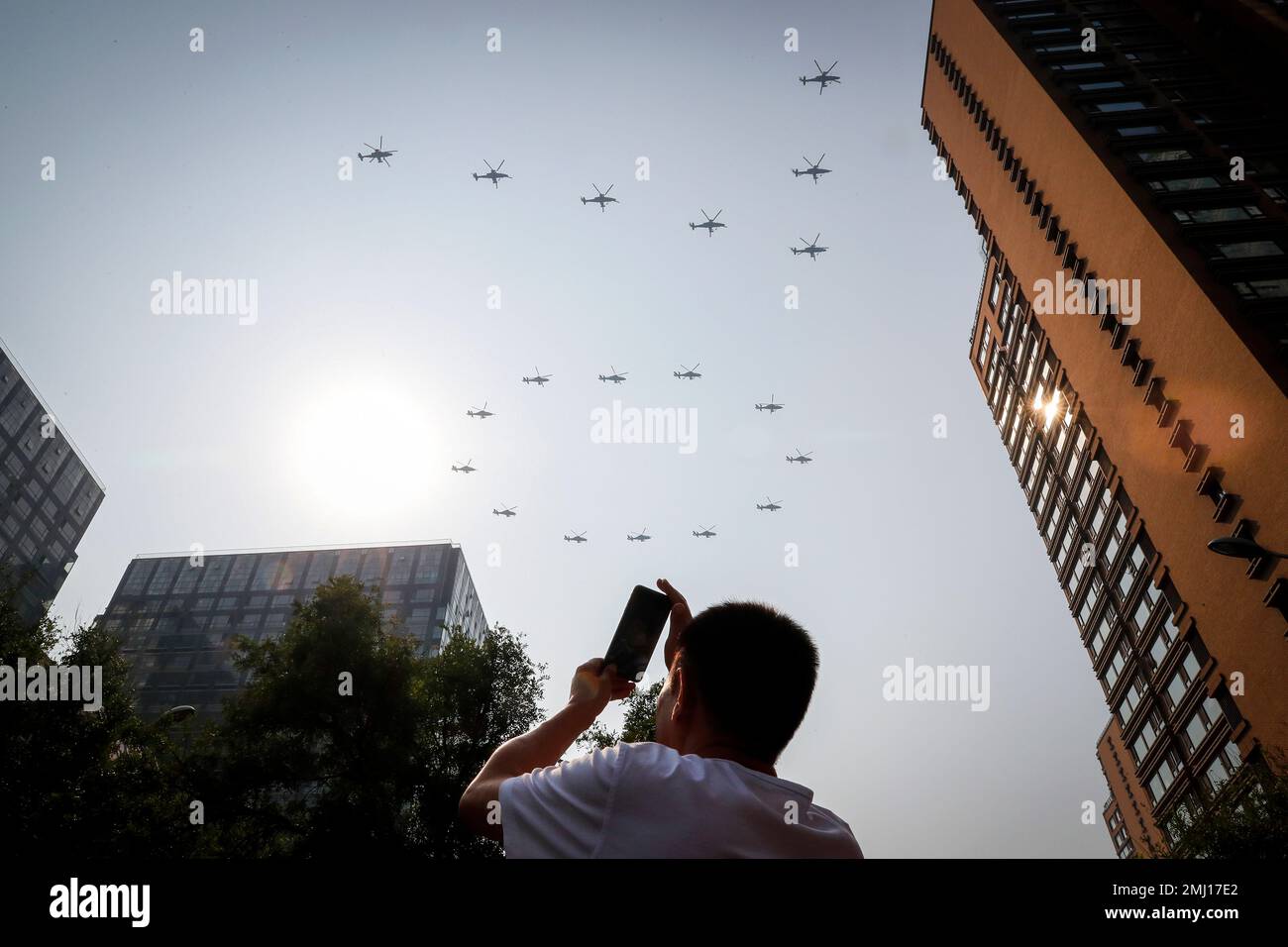 A man uses his smartphone to film Chinese army attack helicopters form ...