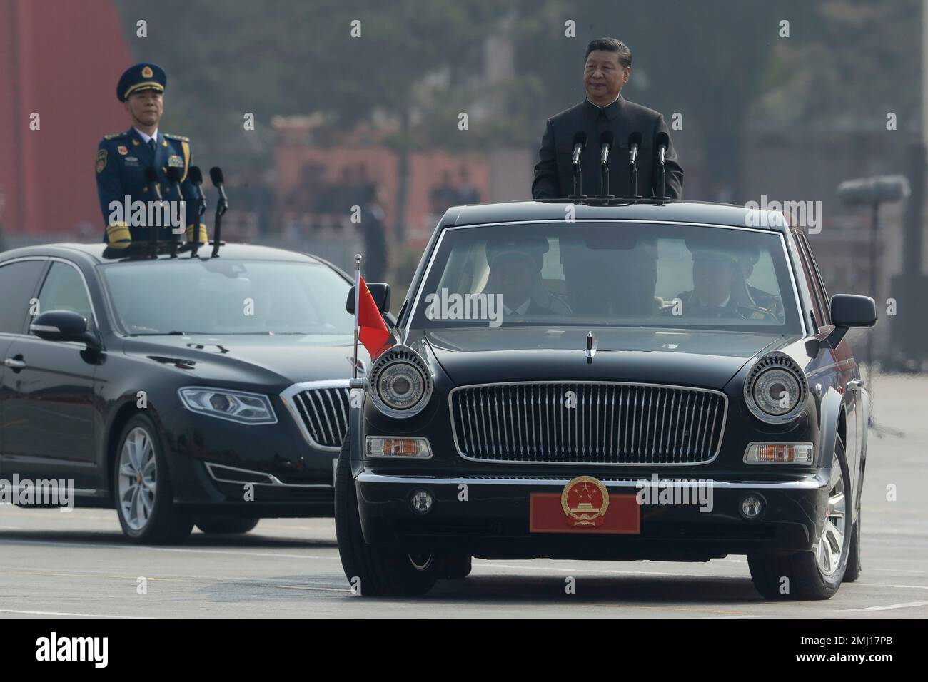 Chinese leader Xi Jinping rides in an open-top limousine during a ...