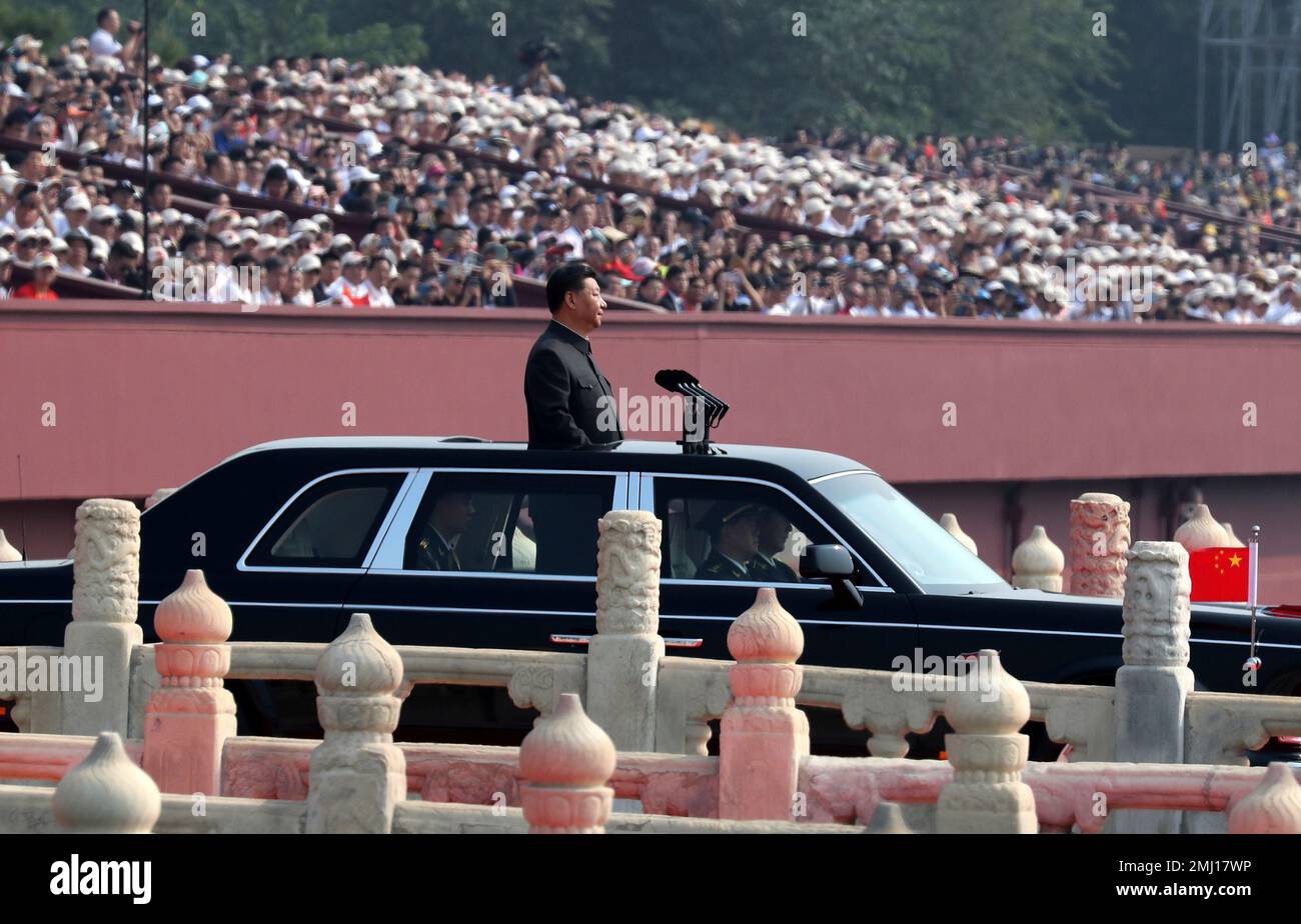Chinese leader Xi Jinping rides in an open-top limousine during a ...
