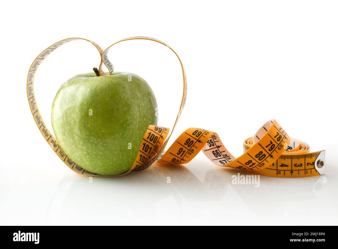 Measuring tape forming a heart and green apple inside reflected on the ...