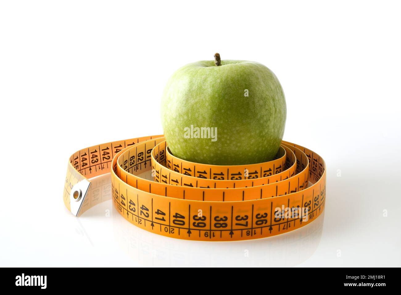 Rolled meter in a circle and apple inside reflected on white base and ...