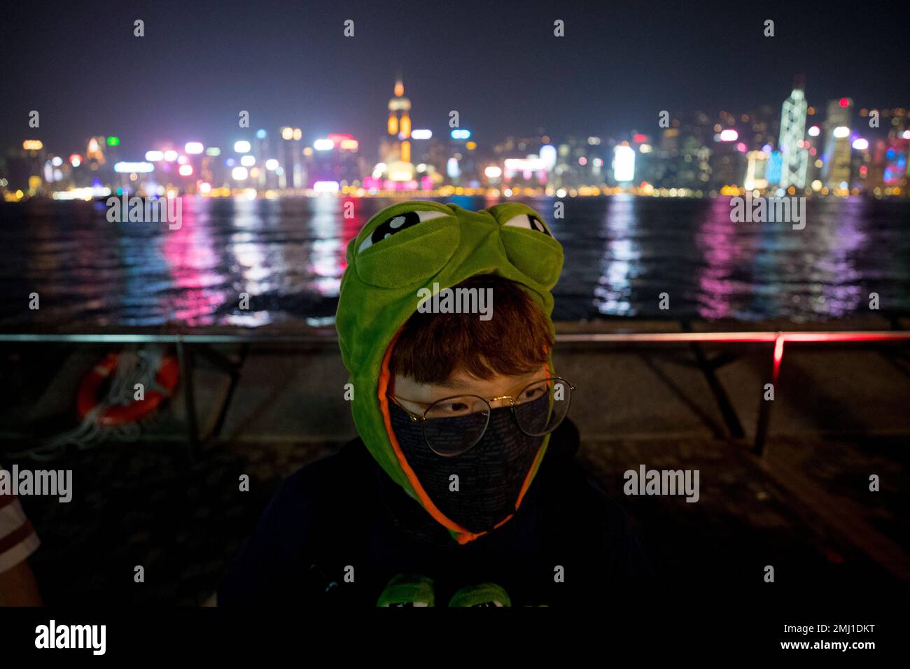 Student wear a Pepe the frog plush toy on his head while forming a long ...
