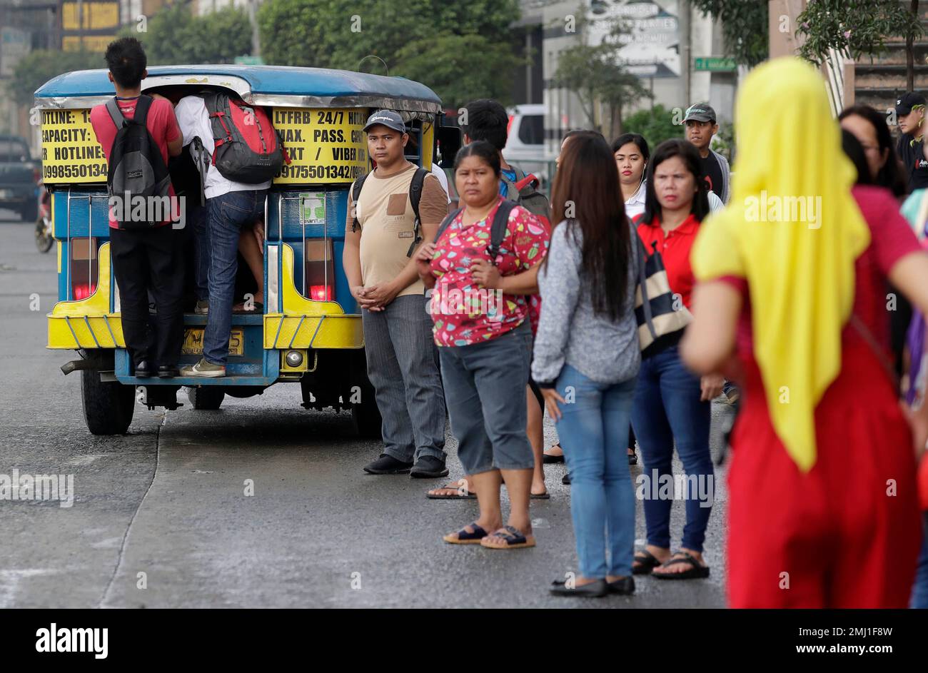 Commuters rush to board a passenger "jeepney" during a transport strike ...