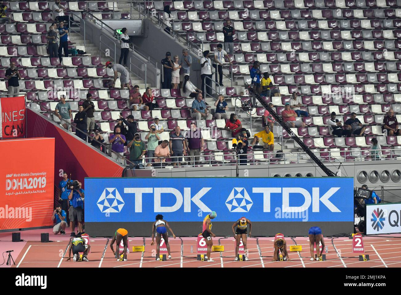 A few spectators on the stands watch as athletes get ready for the ...