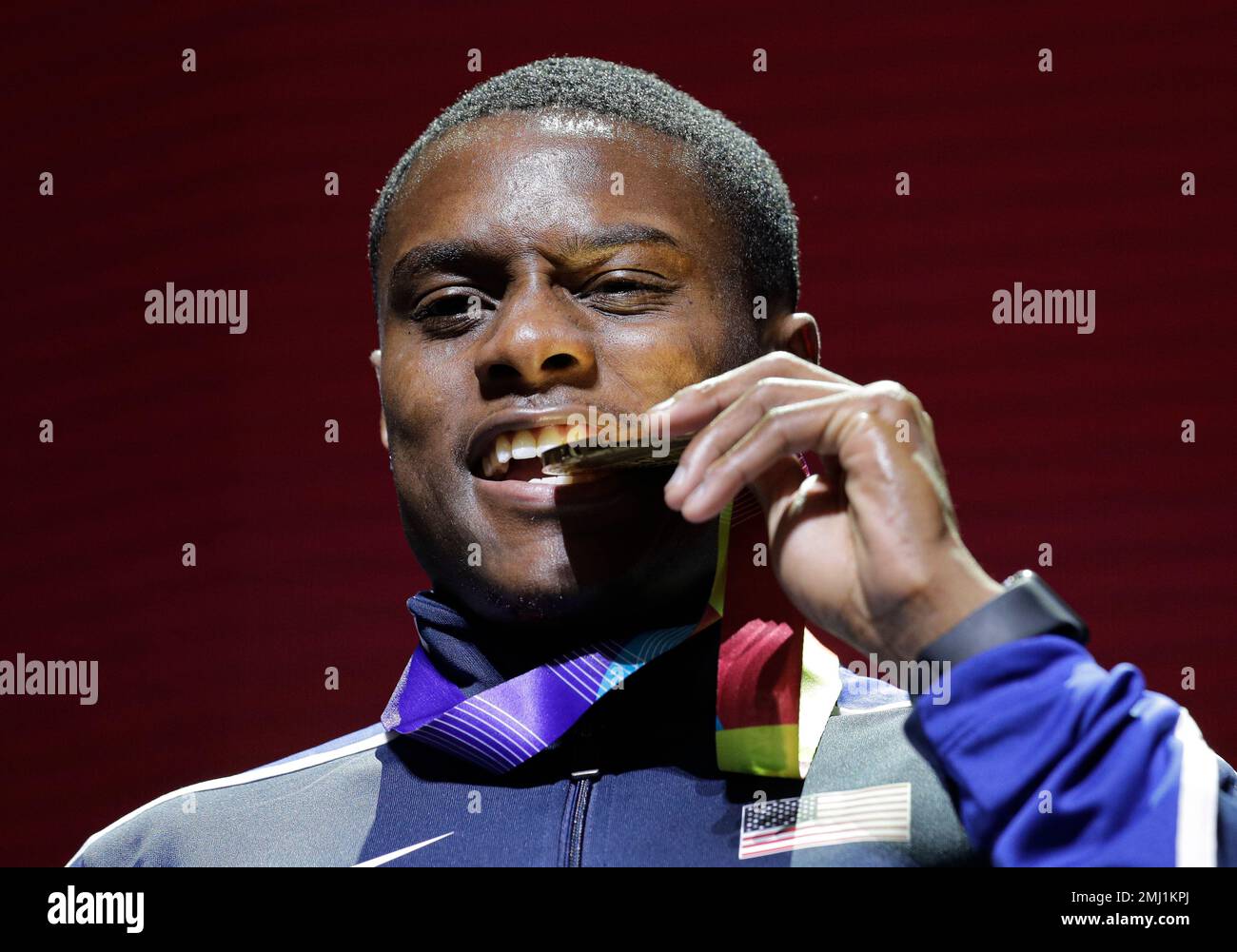 Christian Coleman of the United States, gold winner, bites on his medal ...