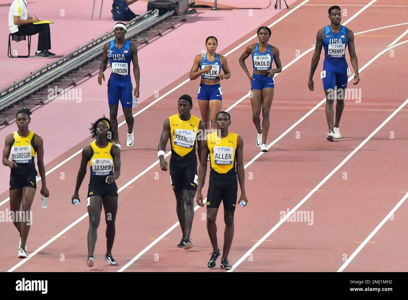 The teams of the United States, background, and Jamaica enter the track ...