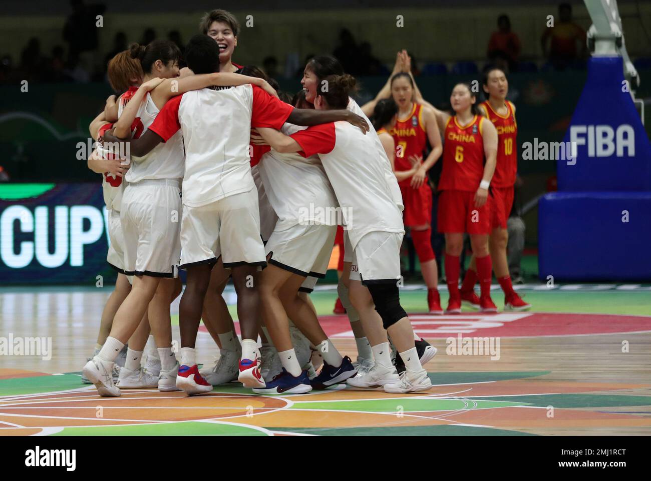 Japanese players, left, celebrate after their win in the FIBA ...